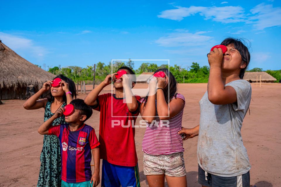 Crianças Wauja da aldeia Topepeweke usando tampa de plástico para ver o ...