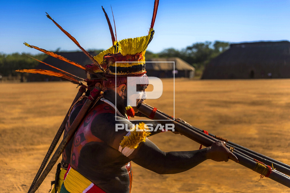 Indígena da aldeia Afukuri etnia Kuikuro tocando flauta uruá na ...