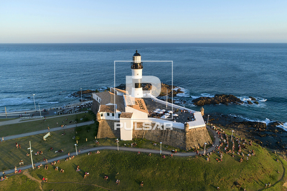 Vista de drone de pessoas aguardando o pôr do sol no entorno do Farol ...