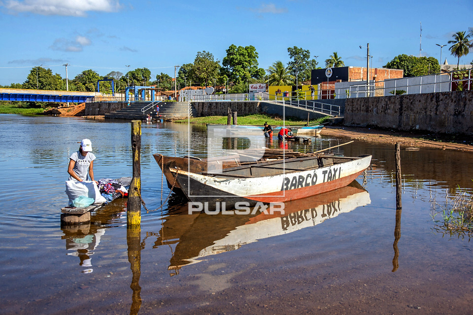 Barco táxi e pessoas lavando roupa no Rio Preto | Pulsar Imagens ...