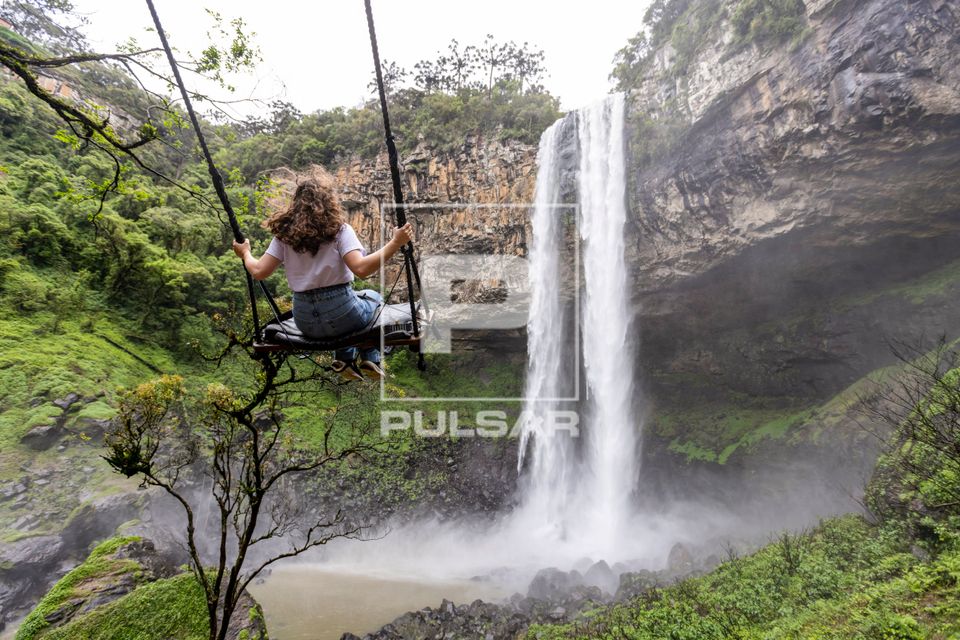 Ecoturista em balanço em frente da Cascata do Caracol formada pelo Rio ...