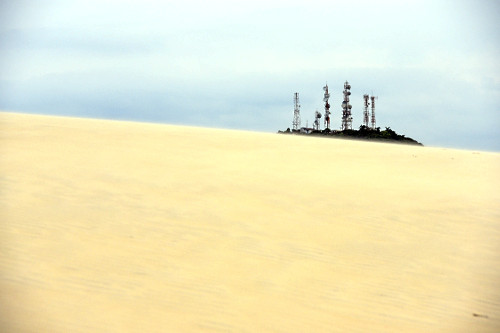 Lagoa em meio as dunas e vegetação com mar ao fundo na Praia do Siriu ...